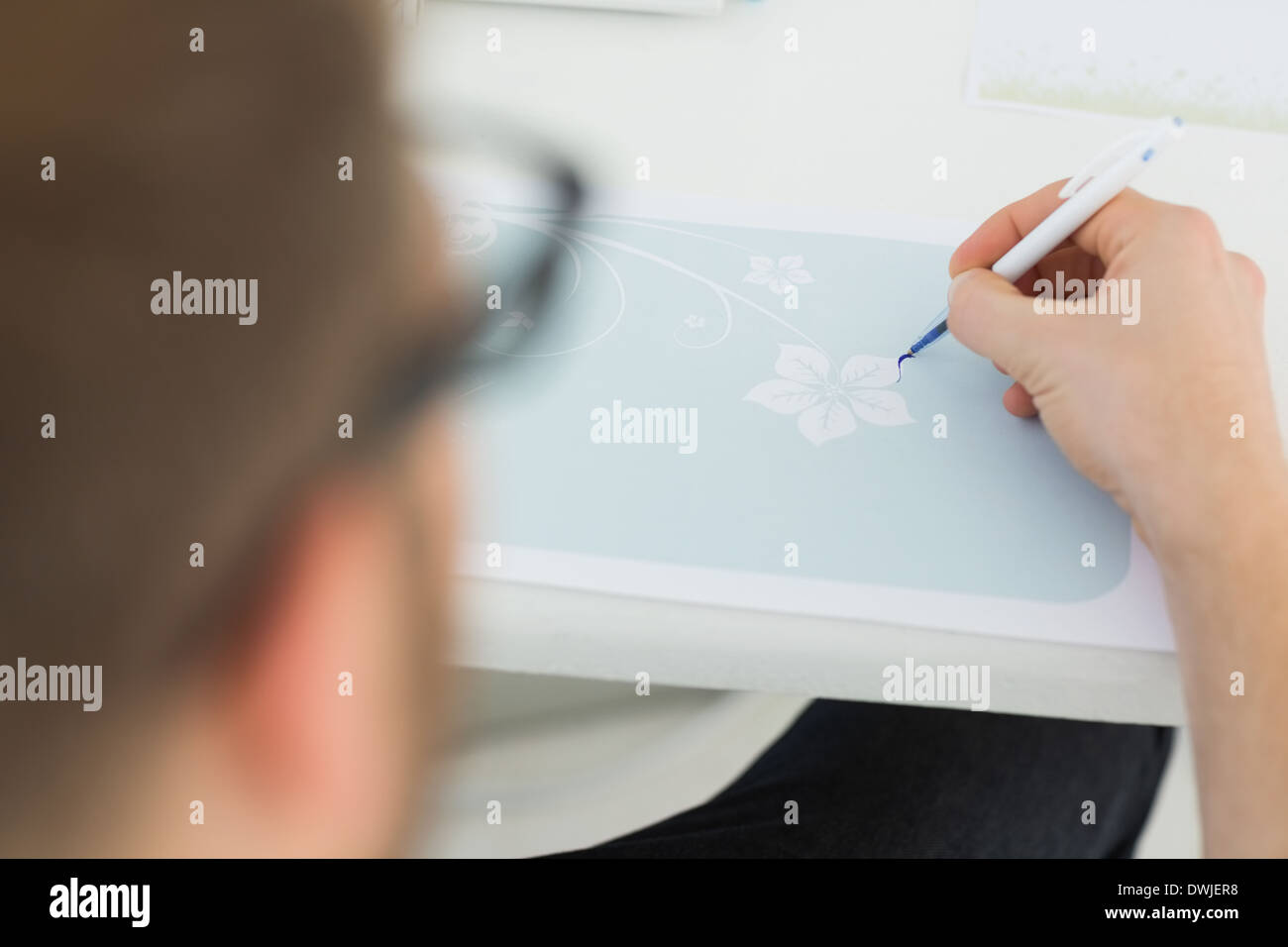 Designer drawing a blue flower design Stock Photo - Alamy