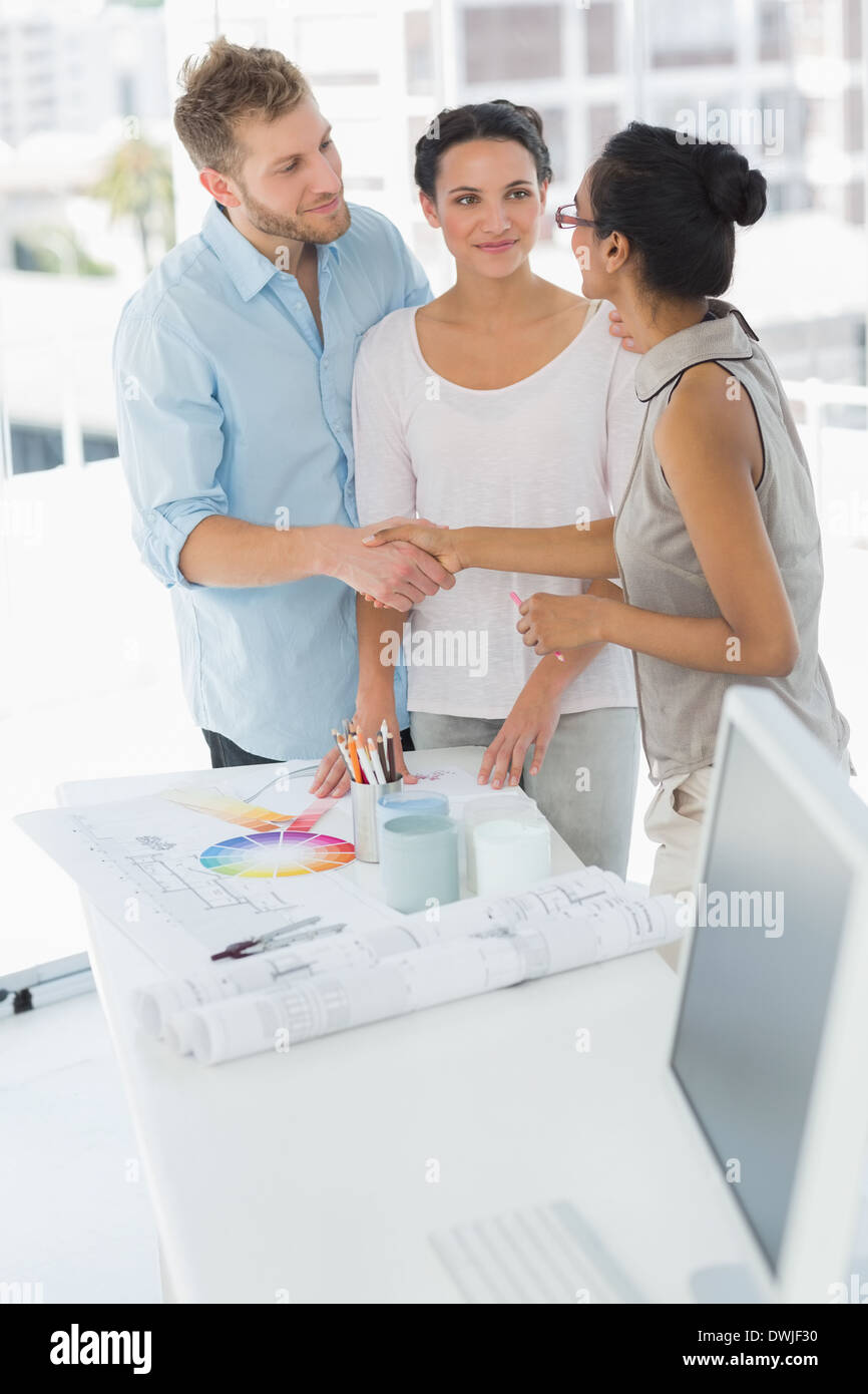 Interior designer shaking hands with happy client Stock Photo - Alamy