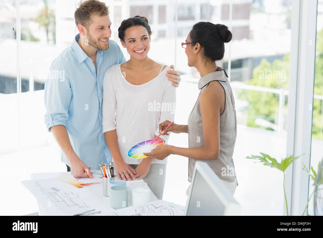 Interior designer showing colour wheel to happy young clients Stock ...