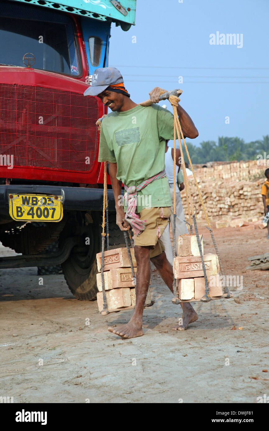 Brick field workers carrying complete finish brick from the kiln, and ...