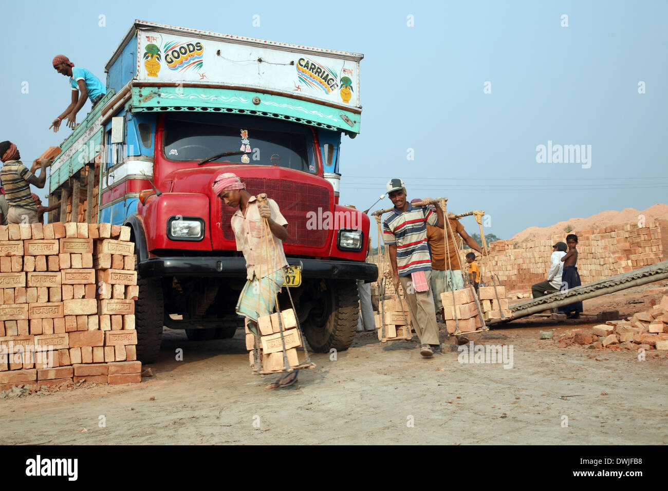 Brick field workers carrying complete finish brick from the kiln, and ...