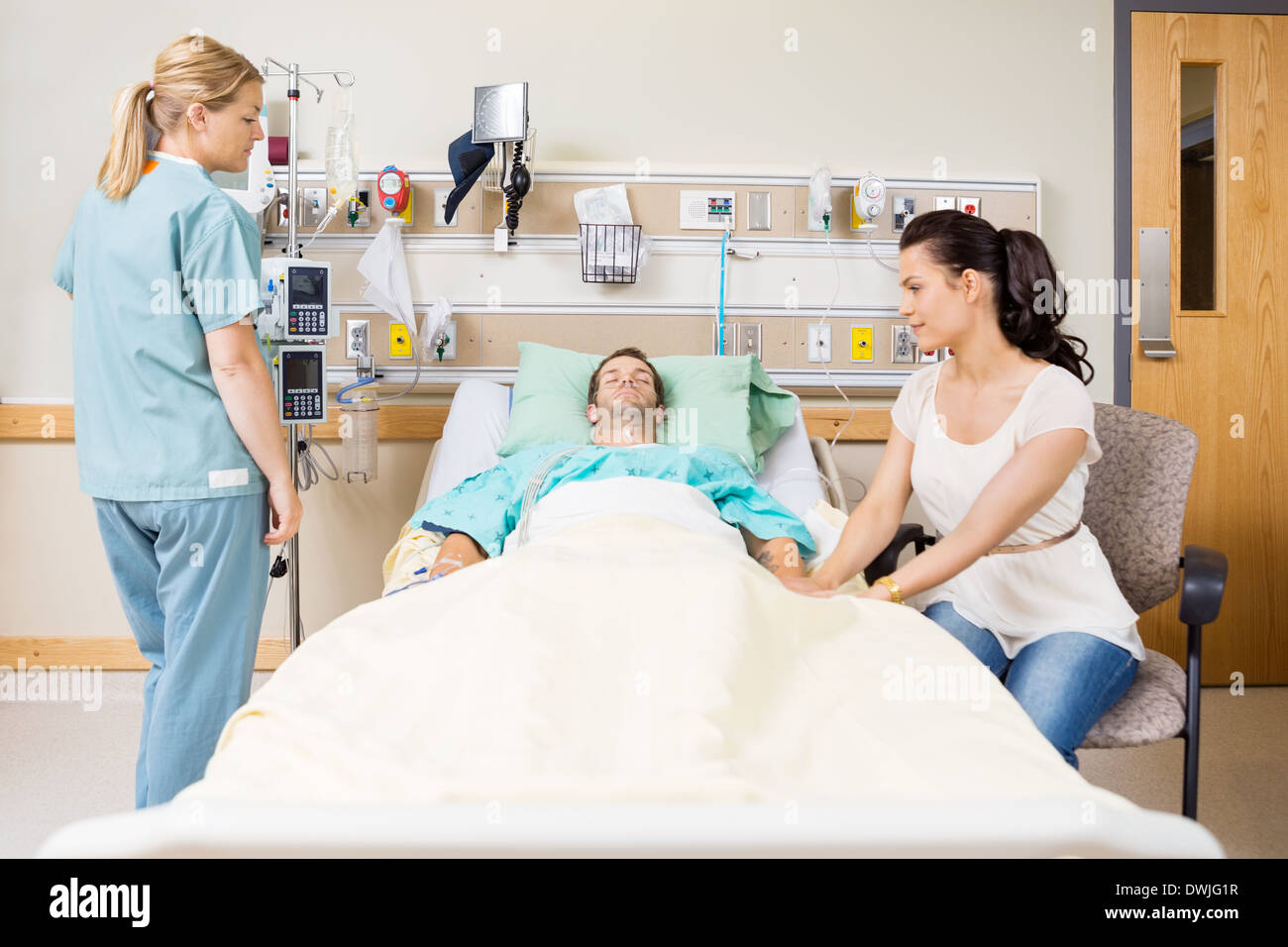 Woman Holding Patient's Hand In Hospital Room Stock Photo - Alamy