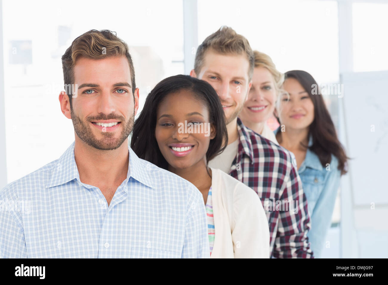 Design team standing in a line smiling at camera Stock Photo - Alamy