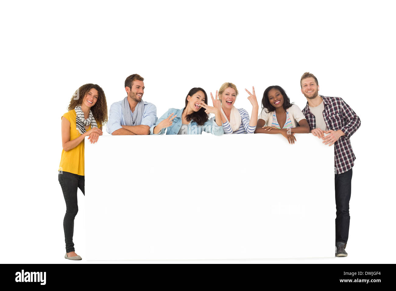 Happy group of young friends leaning on large poster Stock Photo - Alamy