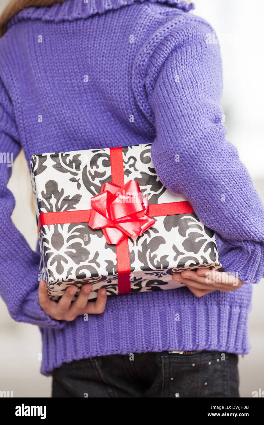 Girl Hiding Christmas Gift Behind Back Stock Photo - Alamy