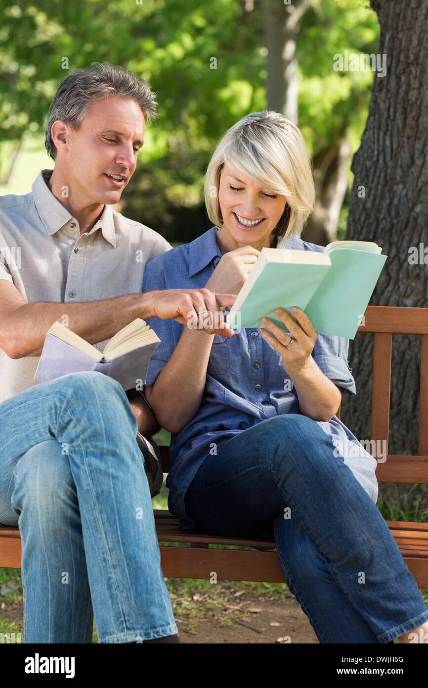 Couple reading books on bench Stock Photo - Alamy