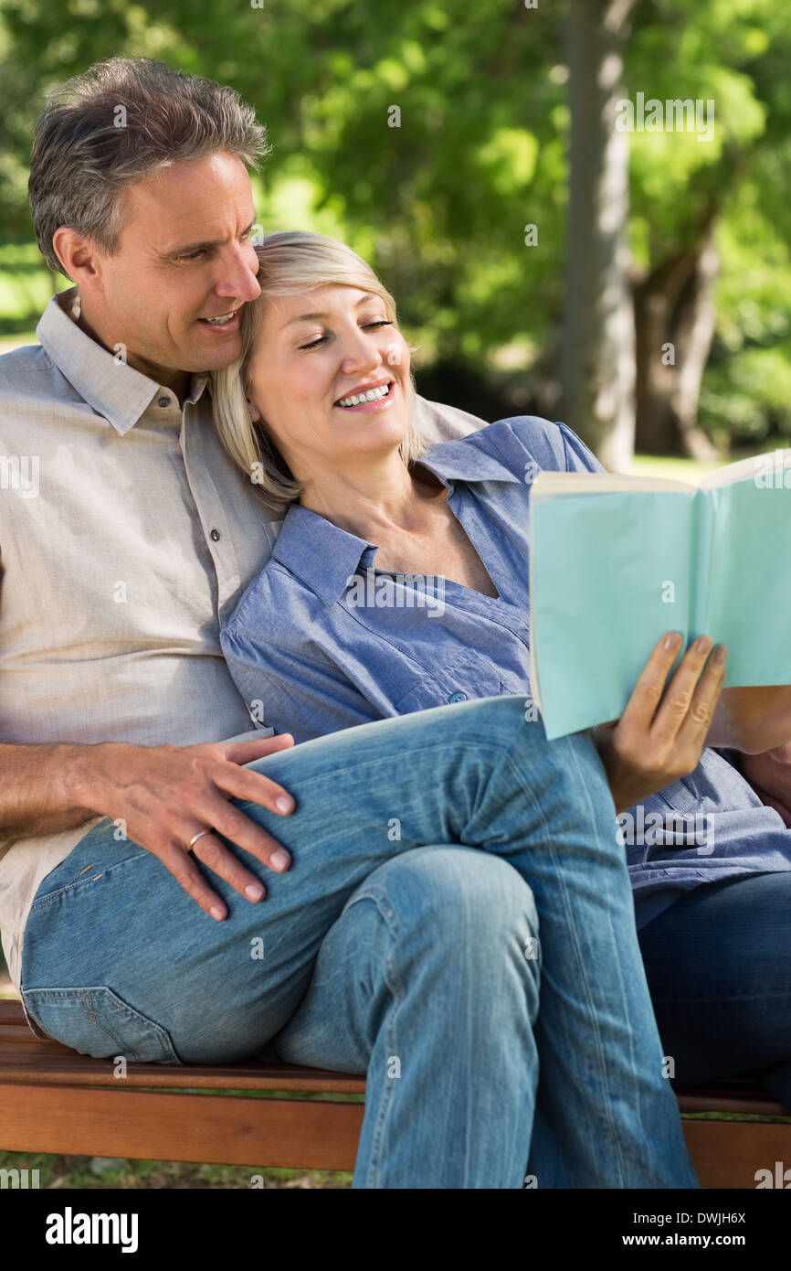 Affectionate couple reading book Stock Photo - Alamy