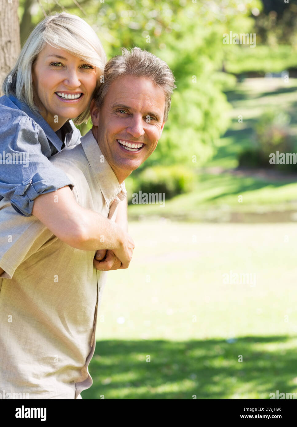 Couple enjoying piggyback ride in park Stock Photo - Alamy