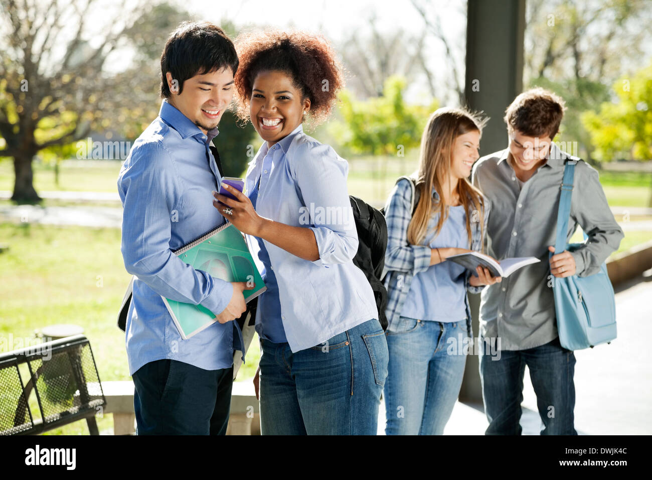 Student Showing Cellphone To Friend At Campus Stock Photo - Alamy