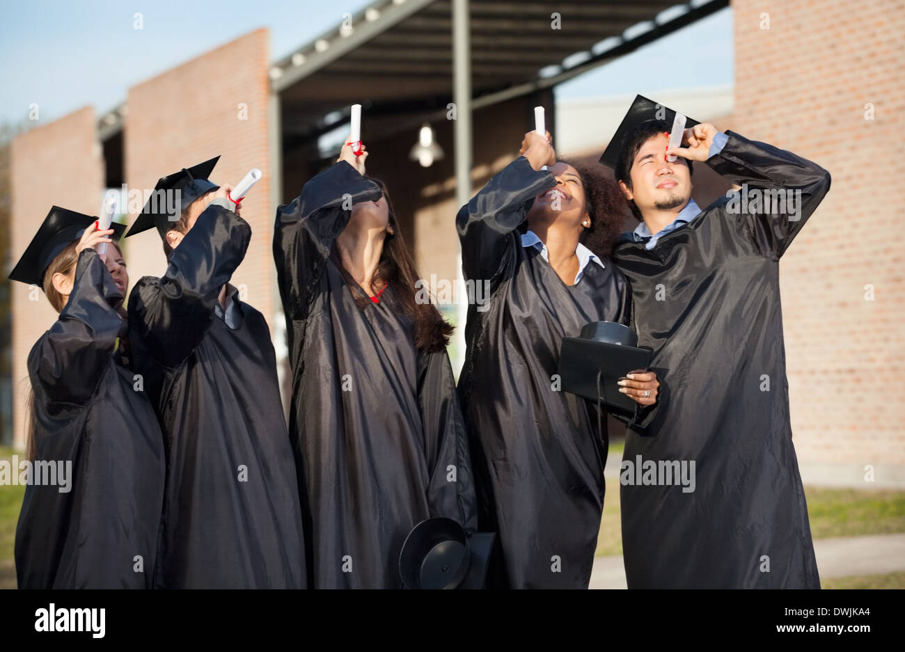 Students In Graduation Gown Looking Through Certificates On Camp Stock ...