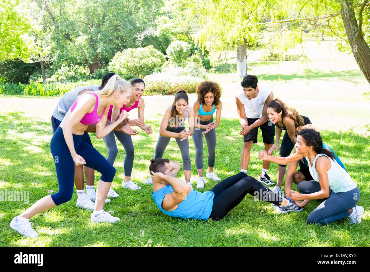 Friends cheering man doing sit ups Stock Photo - Alamy