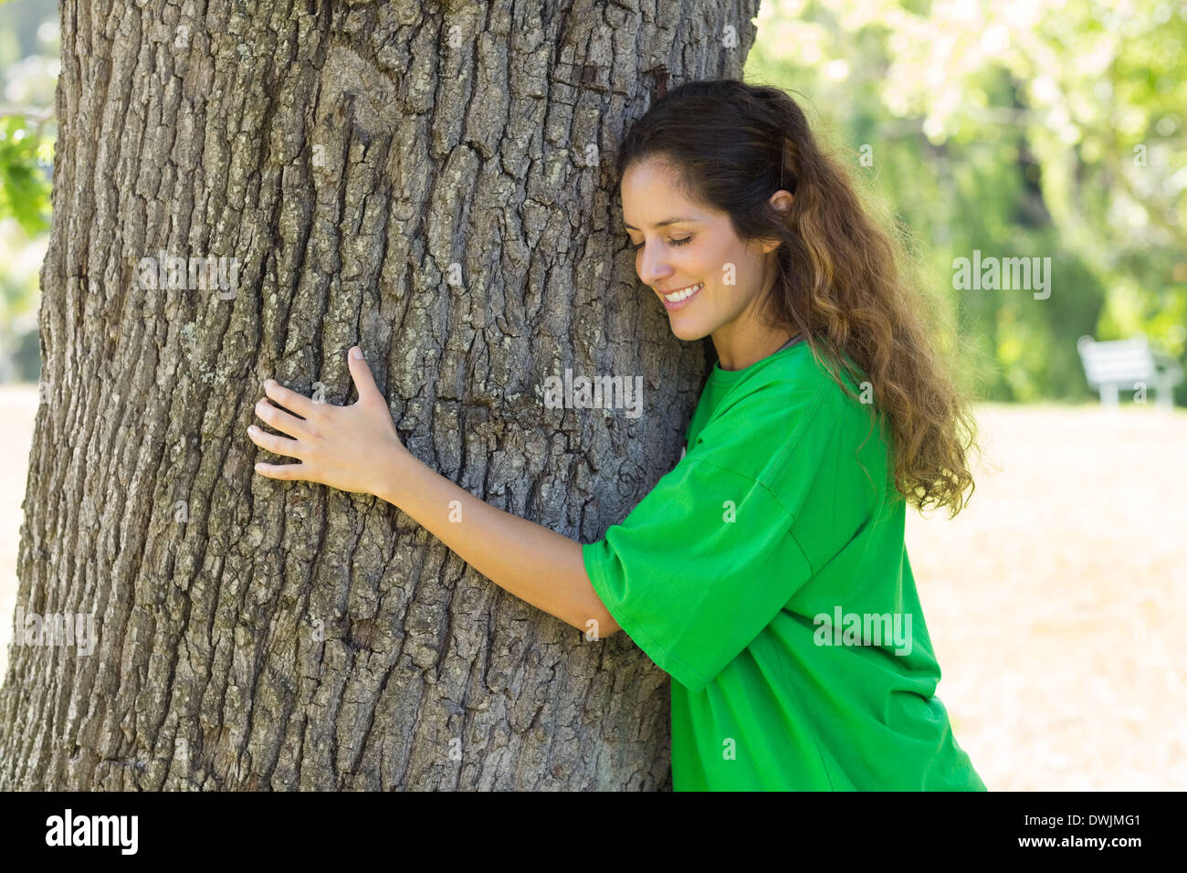 Beautiful environmentalist embracing tree trunk Stock Photo - Alamy