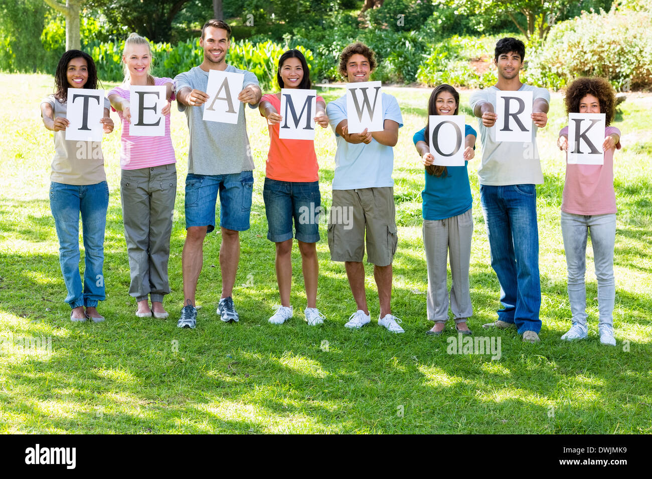 Friends holding placards reading teamwork Stock Photo - Alamy
