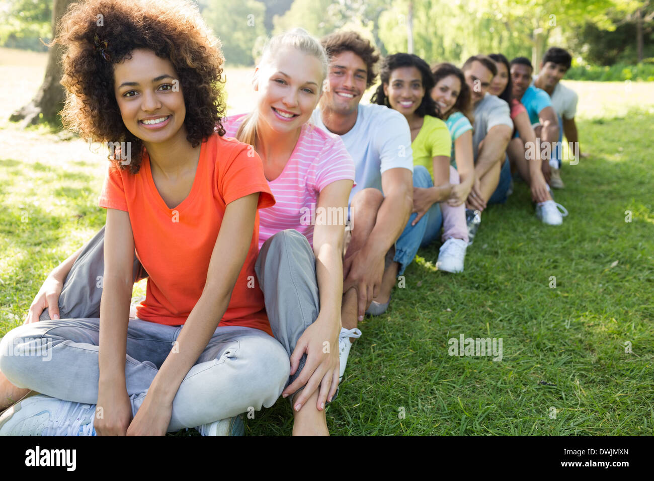 Multiethnic friends sitting in a line Stock Photo - Alamy
