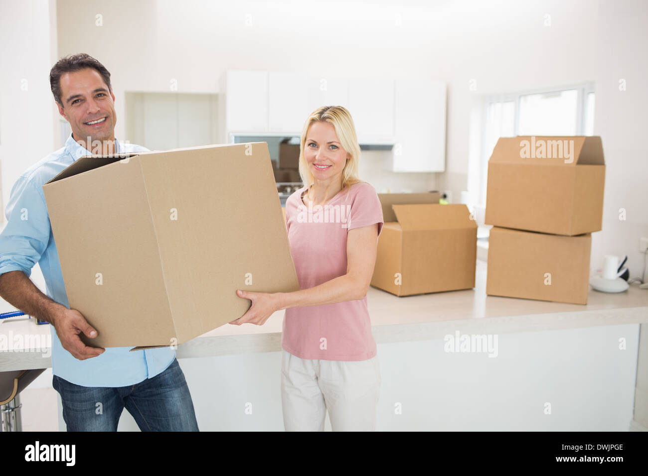 Smiling couple moving together in a new house Stock Photo - Alamy