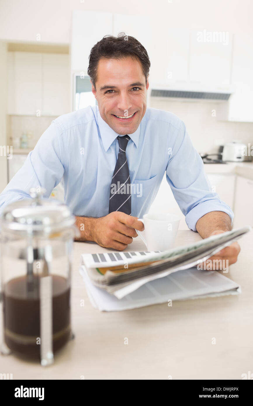 Smiling well dressed man with coffee cup and newspaper in kitchen Stock ...