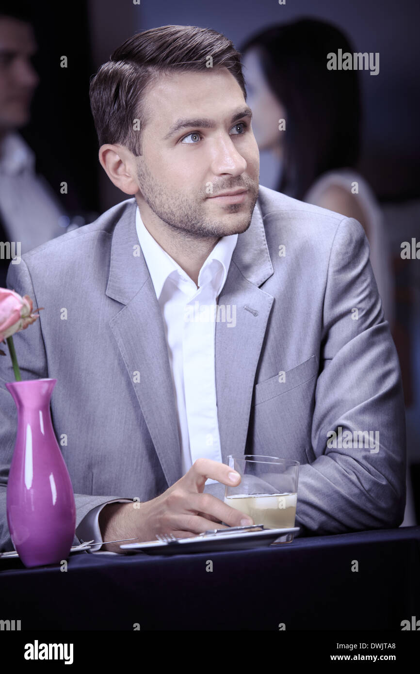 young man at table in a restaurant Stock Photo - Alamy