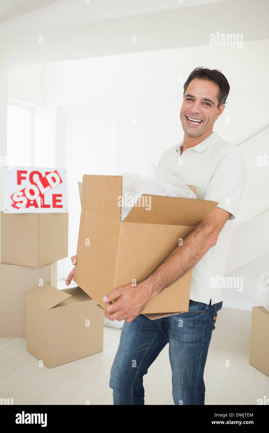 Cheerful man carrying boxes in a new house Stock Photo - Alamy