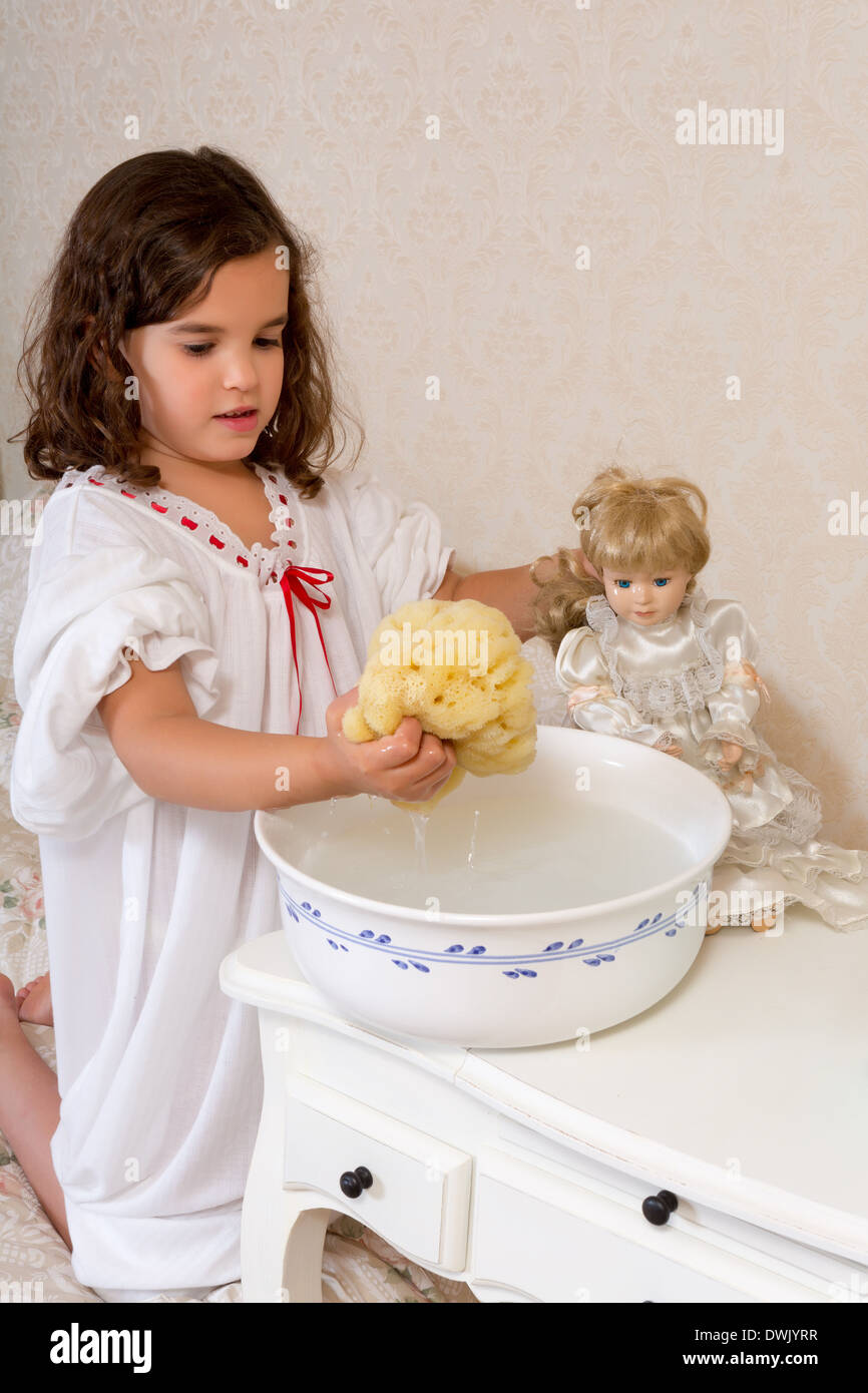 Adorable little victorian girl washing her vintage doll Stock Photo - Alamy