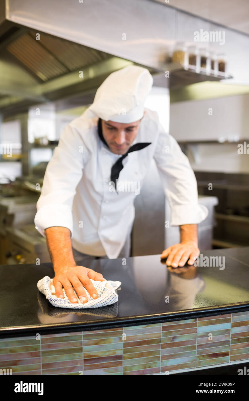 Male cook wiping kitchen counter Stock Photo - Alamy