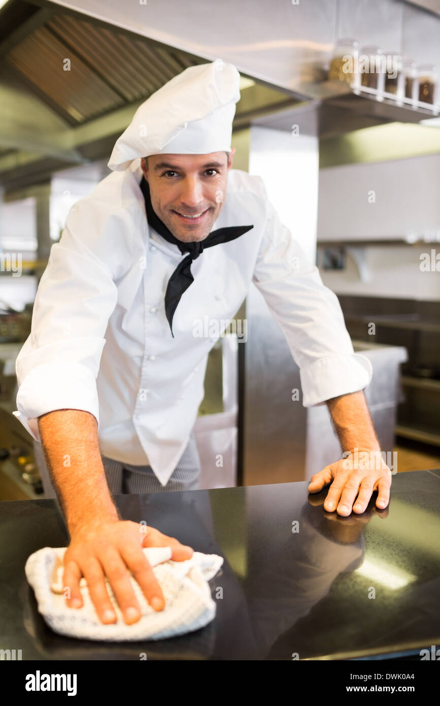Smiling male cook wiping the counter top in kitchen Stock Photo - Alamy