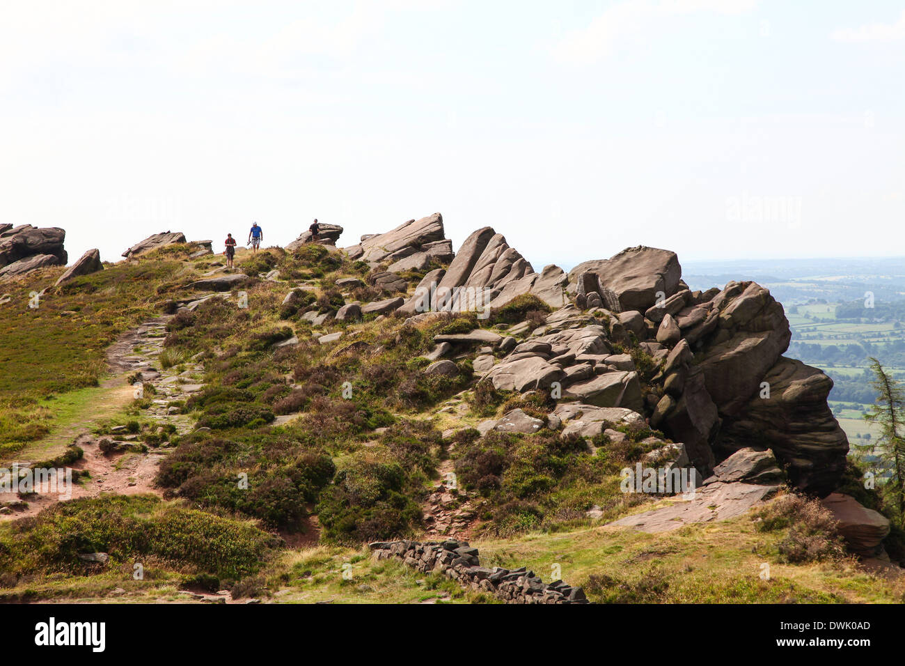 Three people climbing and walking on Hen Cloud at The Roaches ...