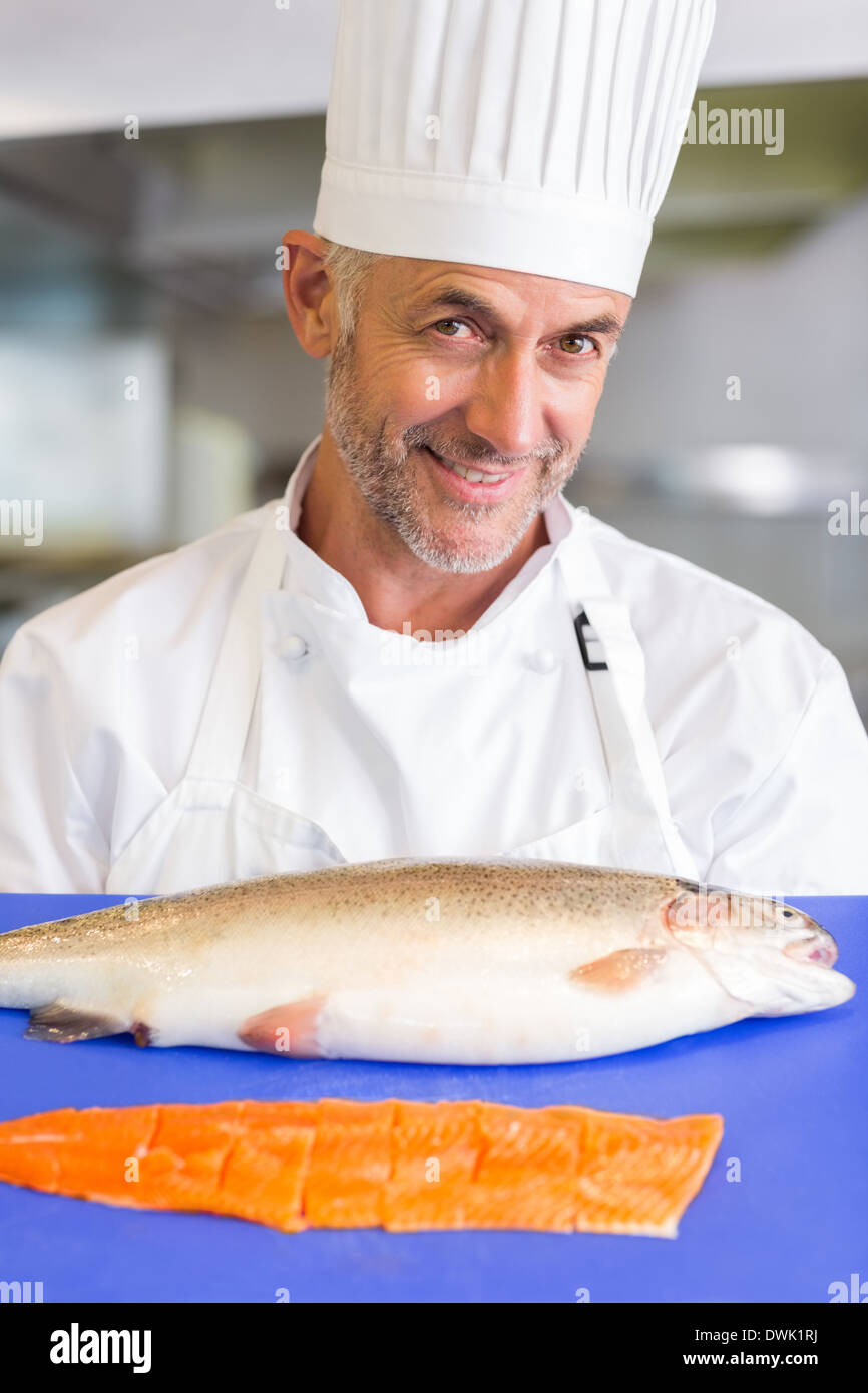Smiling male chef holding tray of raw fish in kitchen Stock Photo - Alamy
