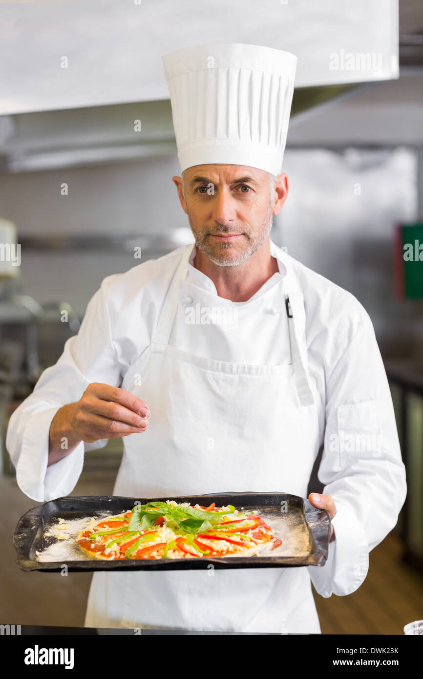 Confident chef holding cooked food in kitchen Stock Photo - Alamy