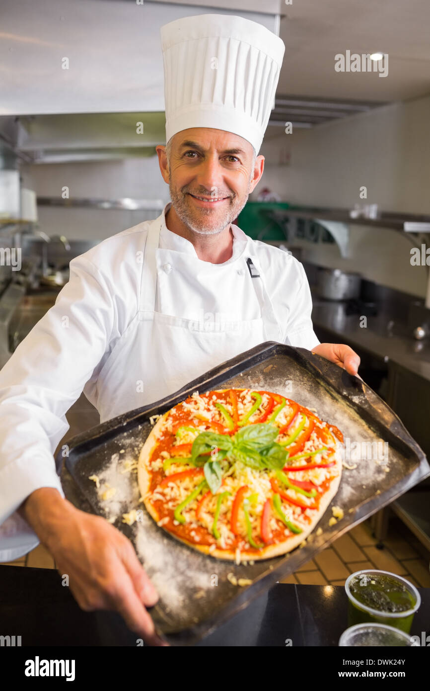 Confident chef holding cooked food in kitchen Stock Photo - Alamy