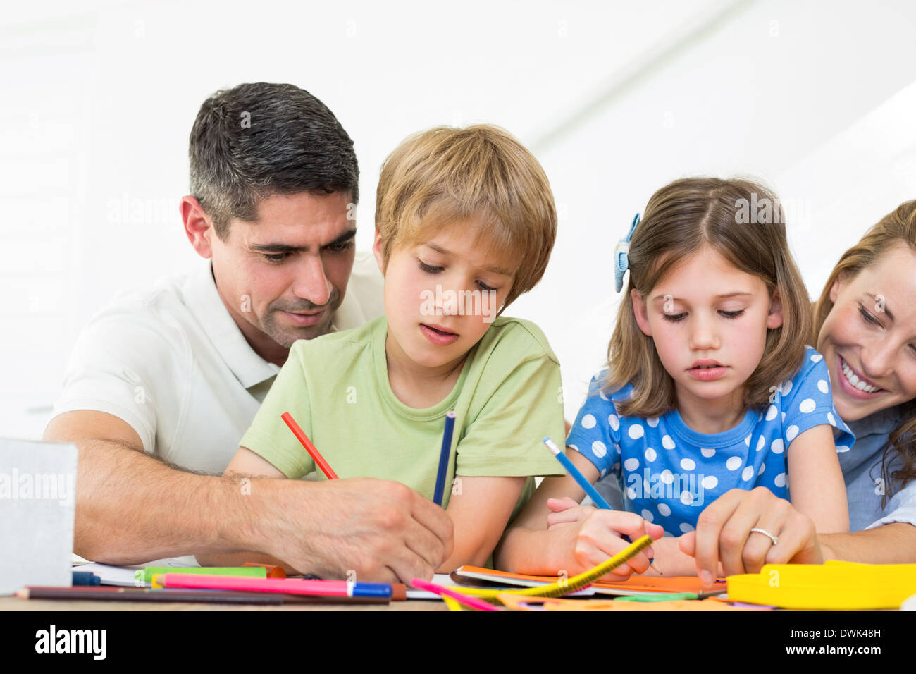 Parents assisting children in coloring Stock Photo - Alamy