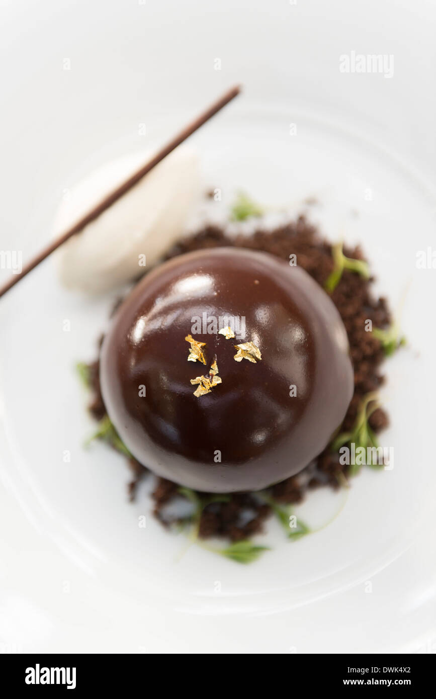 Chocolate bombe dessert served with vanilla ice cream Stock Photo - Alamy