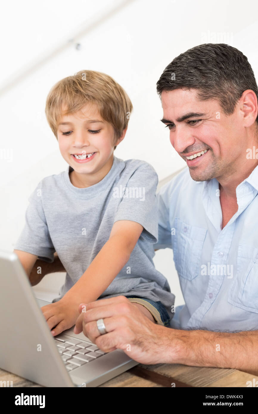 Father reaching son to use laptop Stock Photo - Alamy