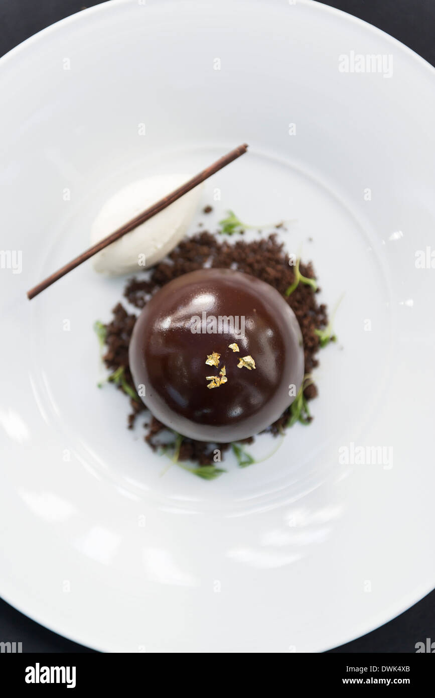 Chocolate bombe dessert served with vanilla ice cream Stock Photo - Alamy