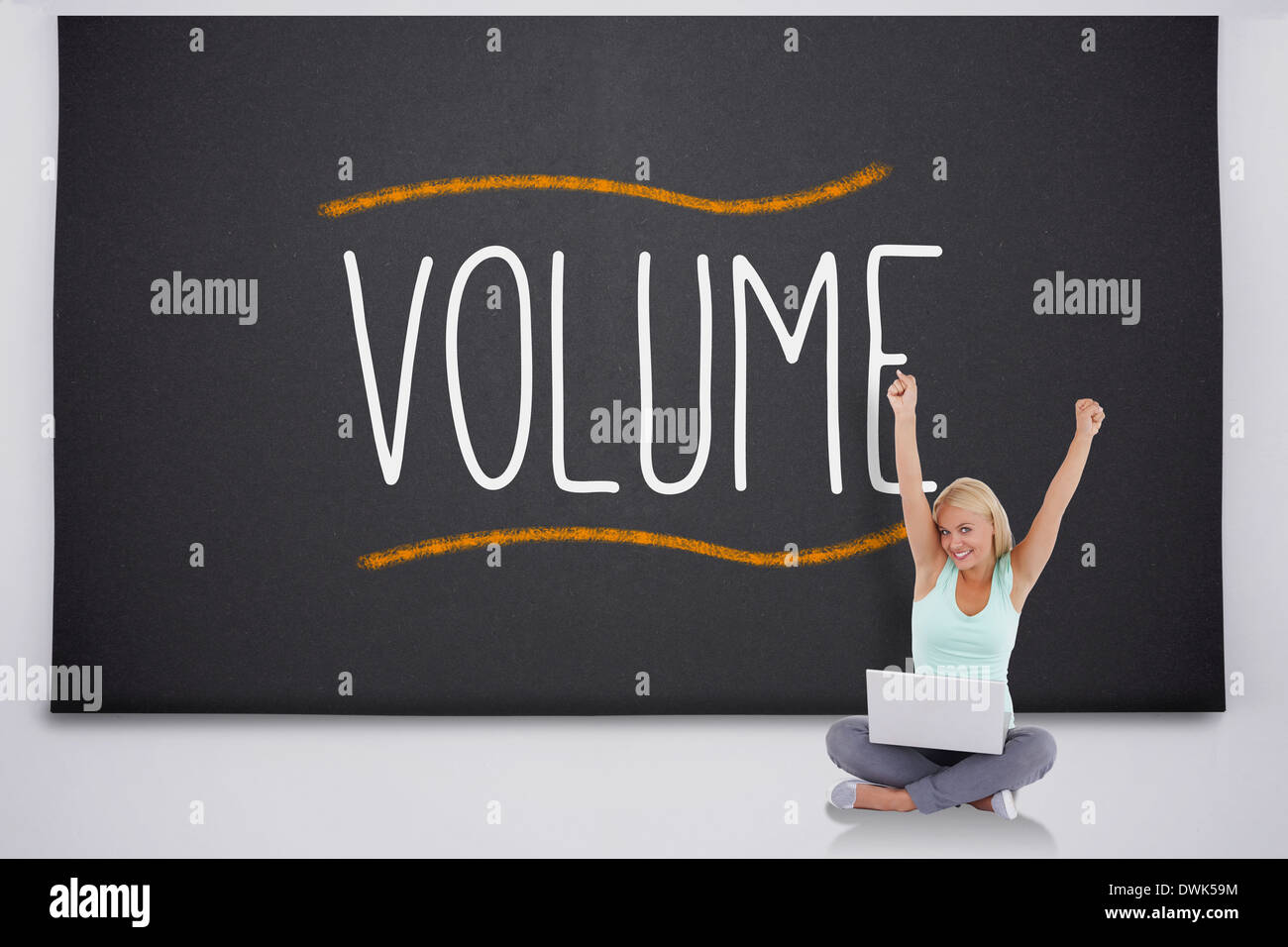 Cheering blonde using laptop against the word volume Stock Photo - Alamy
