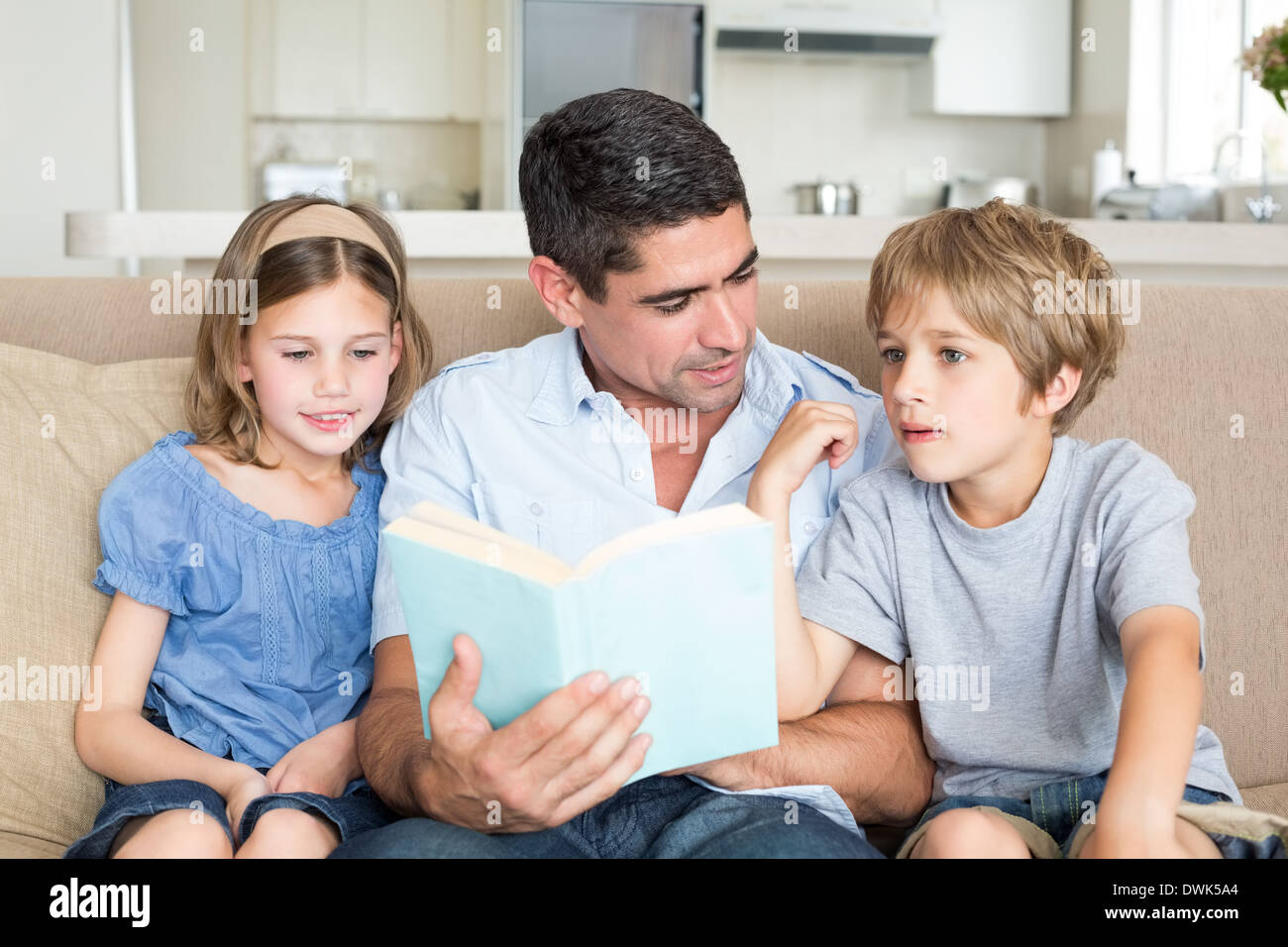 Father teaching children on sofa Stock Photo - Alamy