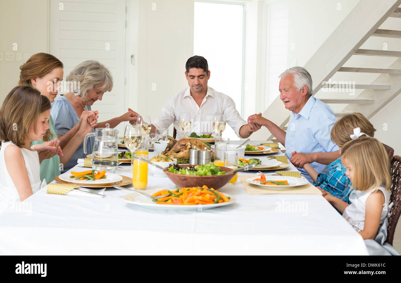 Family praying together before meal at dining table Stock Photo - Alamy