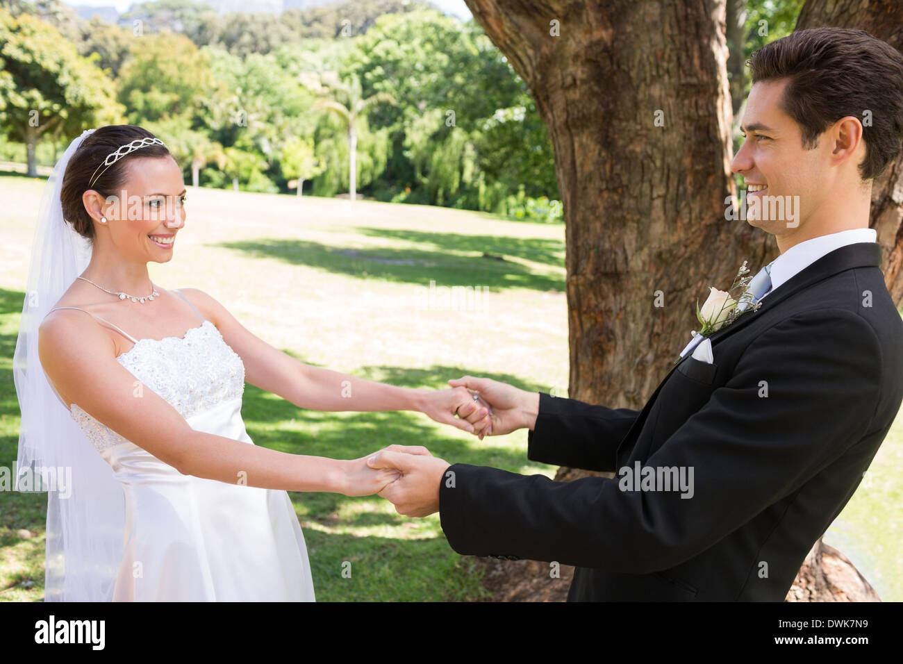 Bride and groom holding hands standing in garden hi-res stock ...