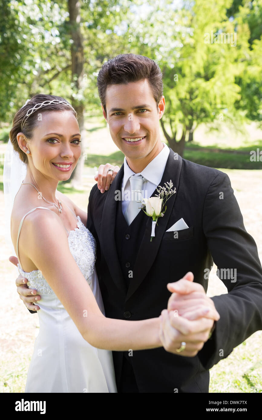 Happy newly wed couple dancing together in garden Stock Photo - Alamy