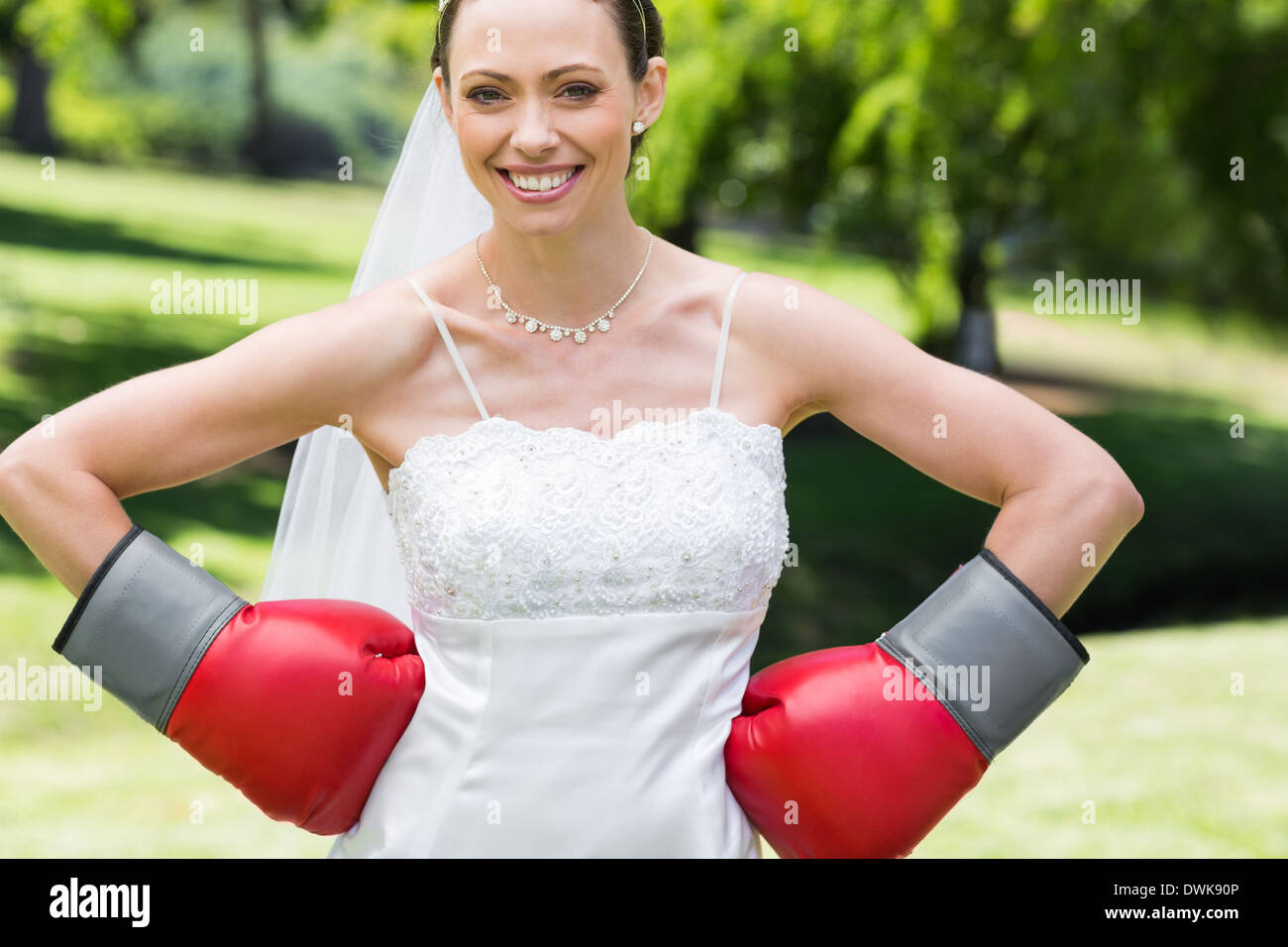 Bride wearing boxing gloves with hands on waist Stock Photo - Alamy