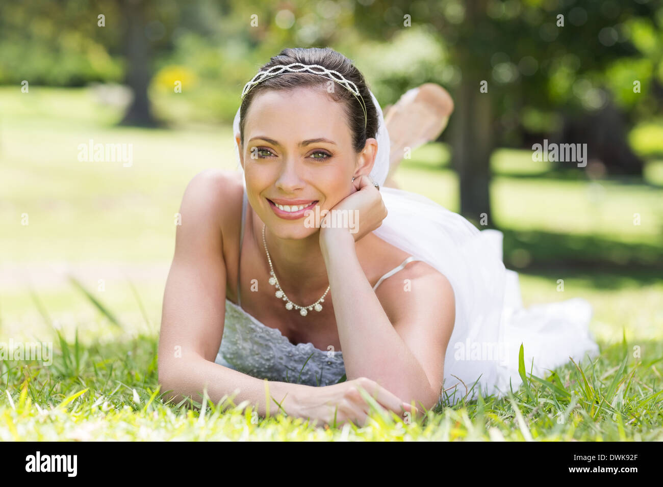 Attractive bride relaxing on grass Stock Photo - Alamy