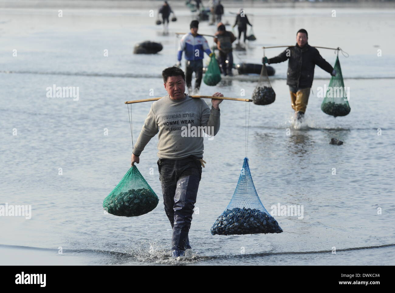 Dalian, China's Liaoning Province. 10th Mar, 2014. Fishermen carry ...