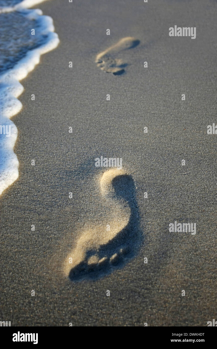 Footprints in the sand on the beach at sunset Stock Photo - Alamy