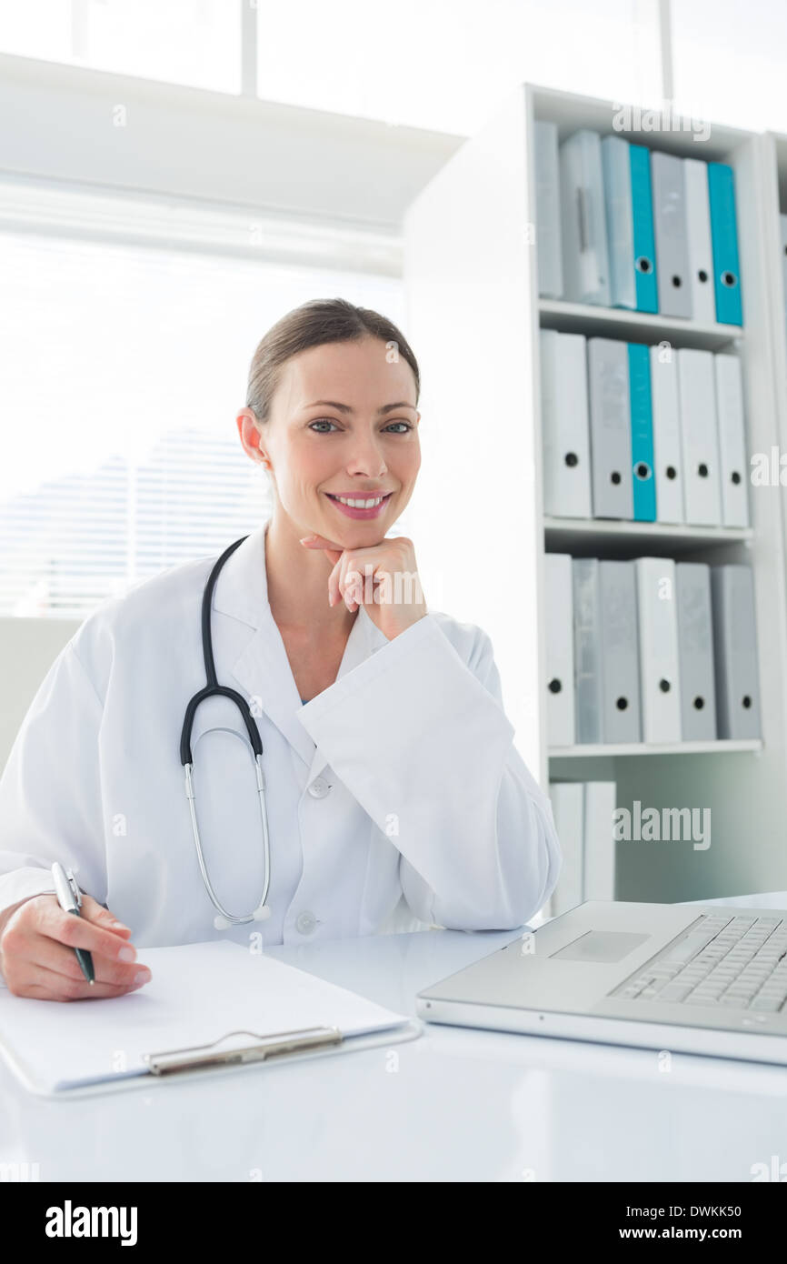 Doctor sitting at desk in clinic Stock Photo - Alamy