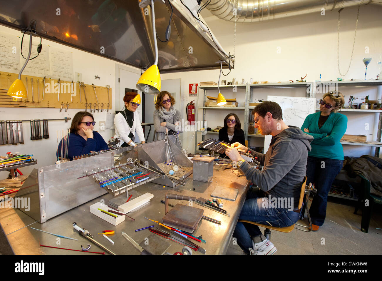 Instructor teaching a group of students to make glass beads, Abate ...