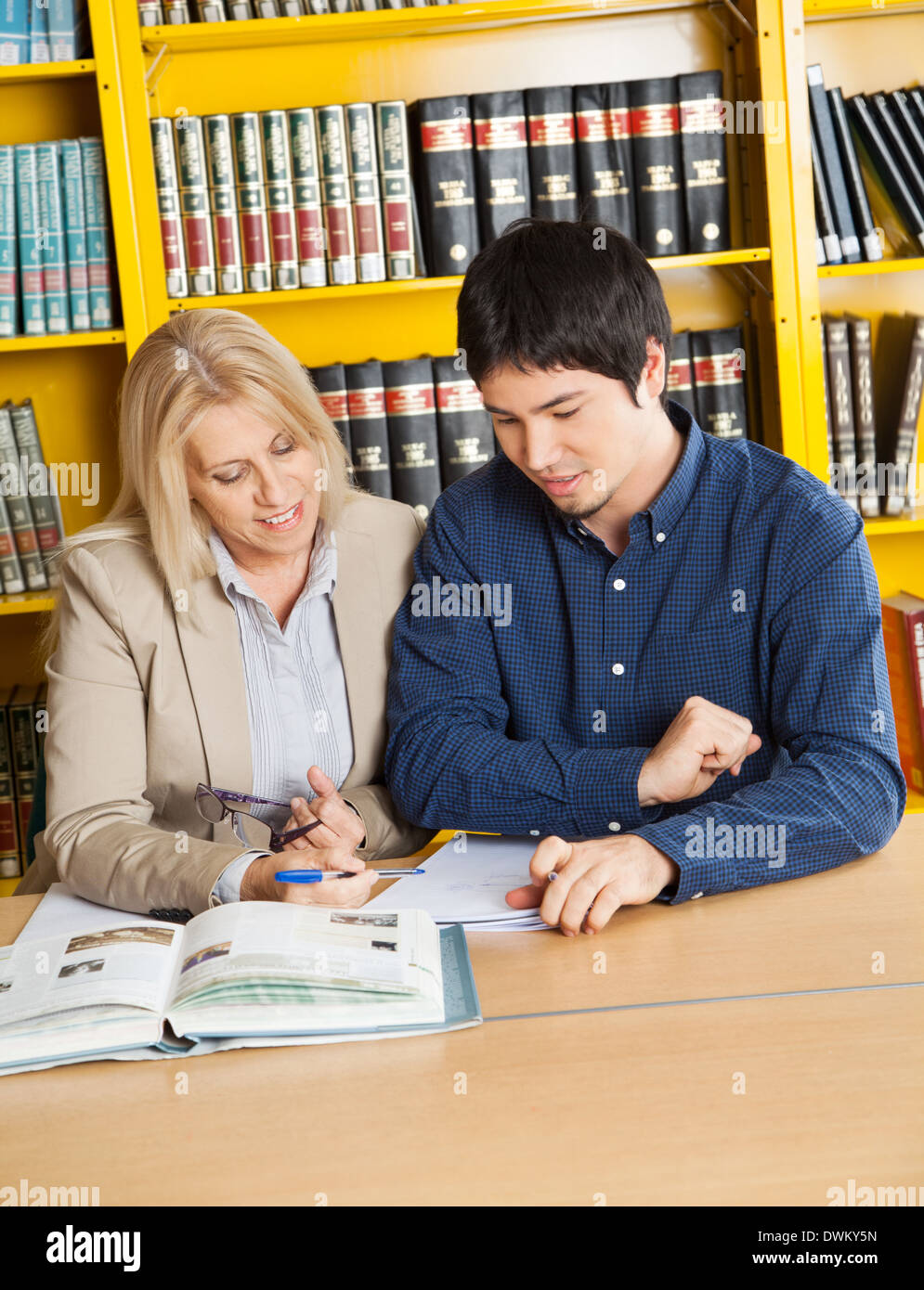 Teacher With Books Explaining Student In University Library Stock Photo ...