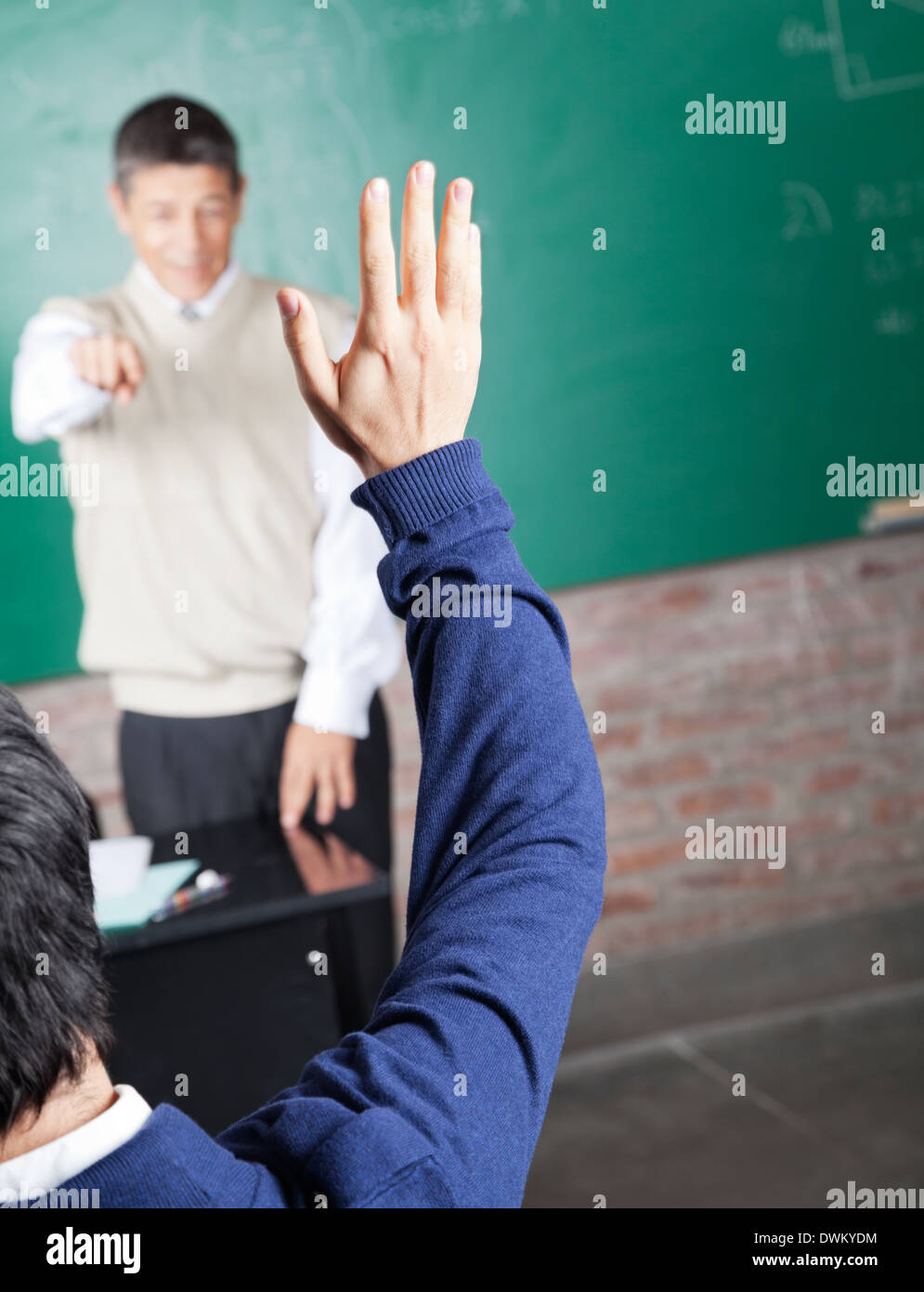 Student Raising Hand To Answer Question In Classroom Stock Photo - Alamy