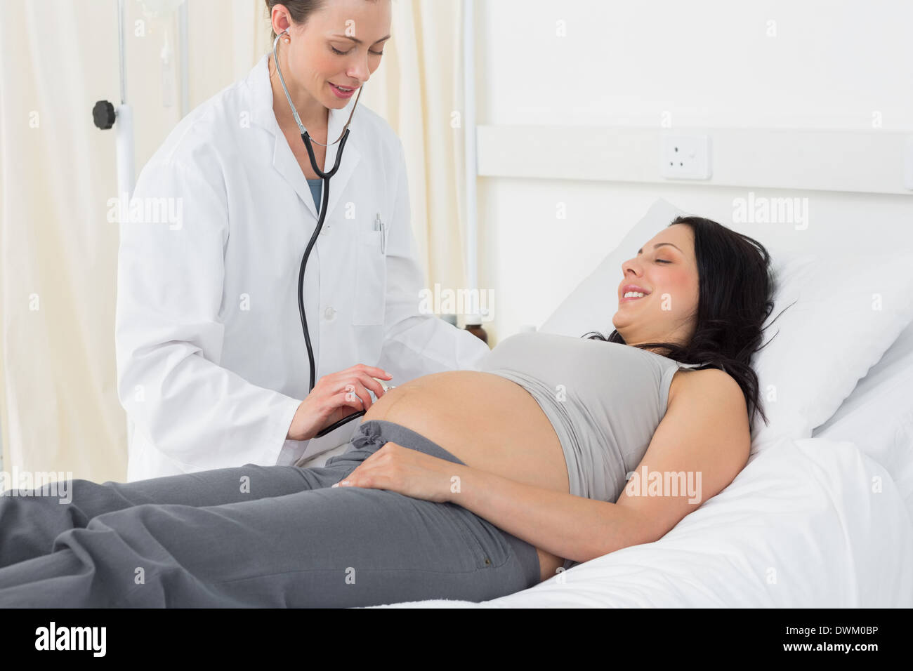 Doctor checking belly of pregnant woman Stock Photo - Alamy