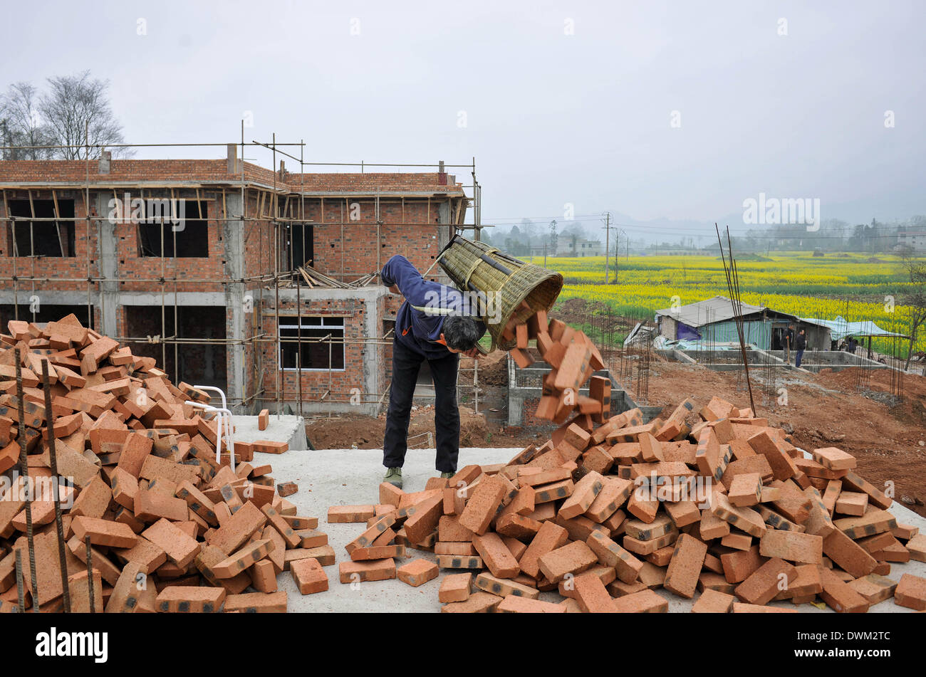 Lushan, March 11. 20th Apr, 2013. A villager carries bricks to rebuild ...