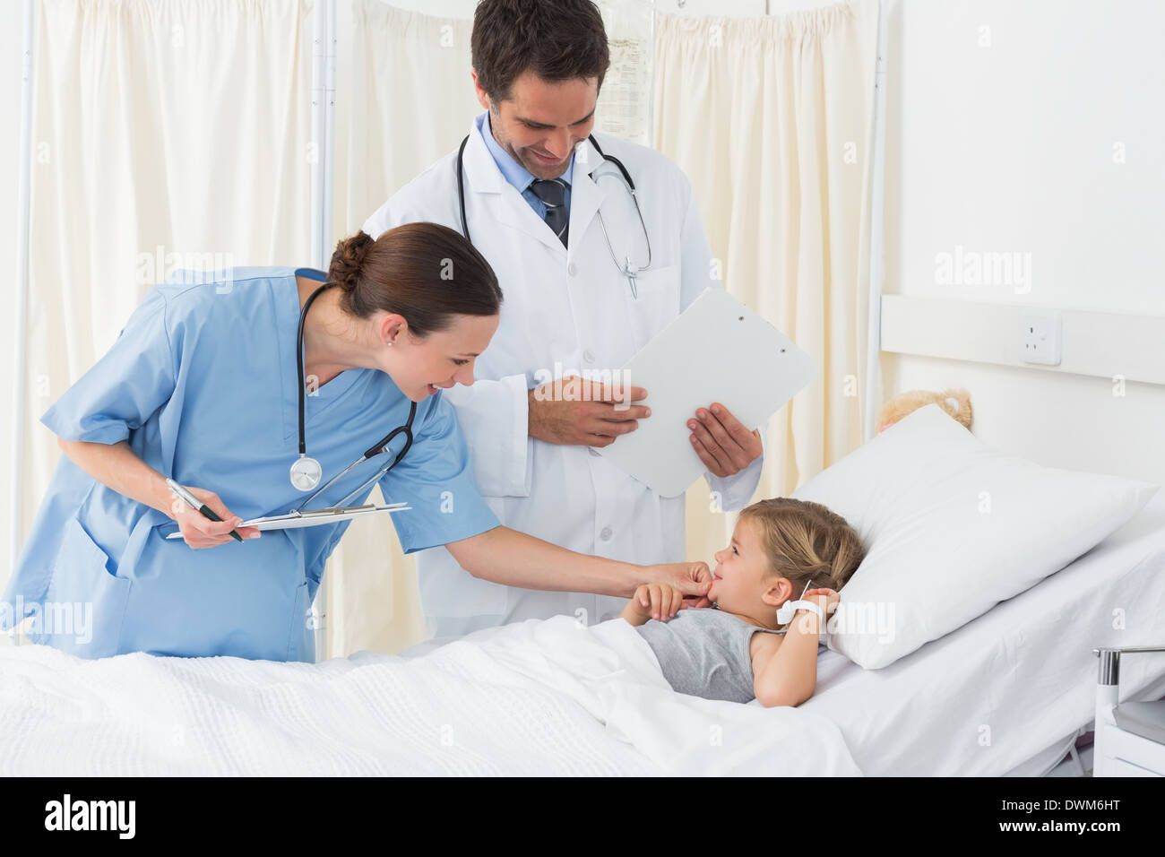 Doctors examining sick girl Stock Photo - Alamy