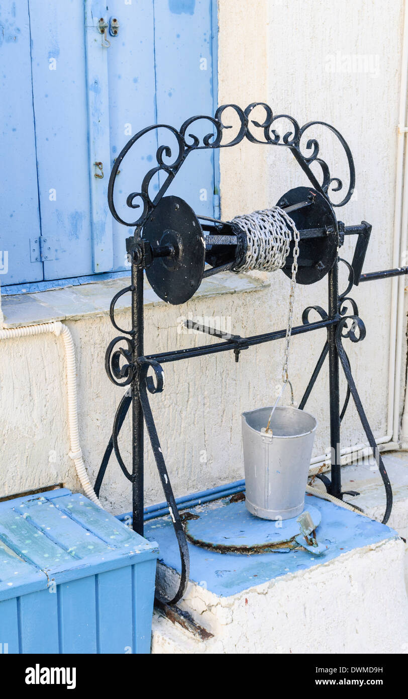 Ornate bucket over a well in the Plaka, Milos Island, Cyclades, Greece ...